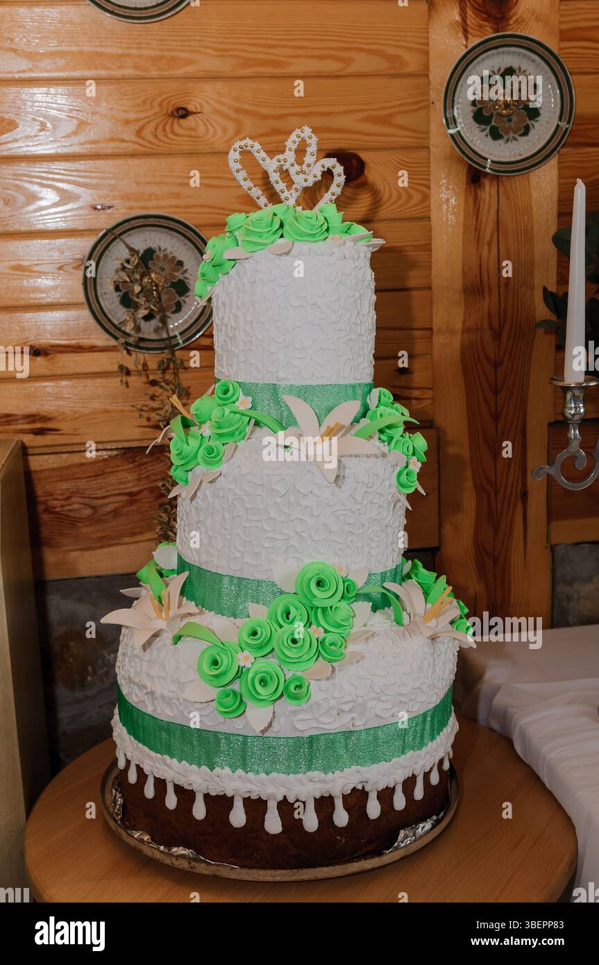 Rustic Wedding Cake Display with Green Accents on Wood Paneling: A ...