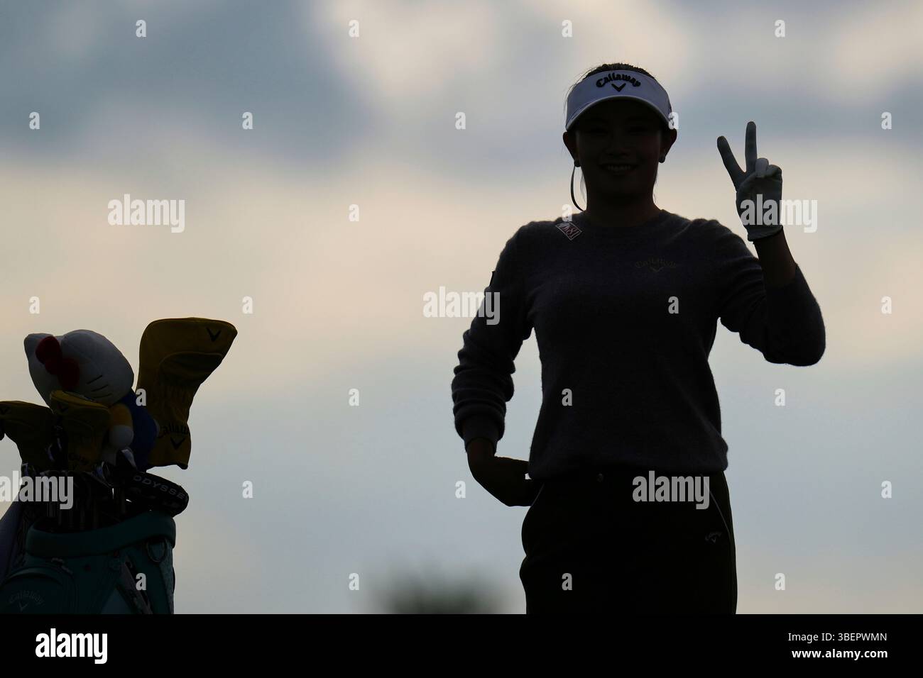 Yui Kawamoto, of Japan, flashes a peace sign before teeing off on the ...