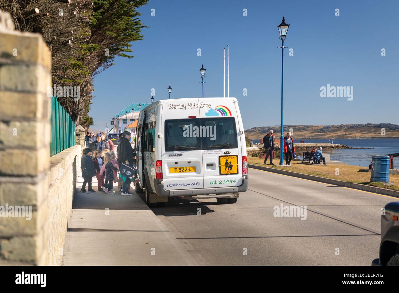 School children board a bus on the main road of the Falkland Islands ...