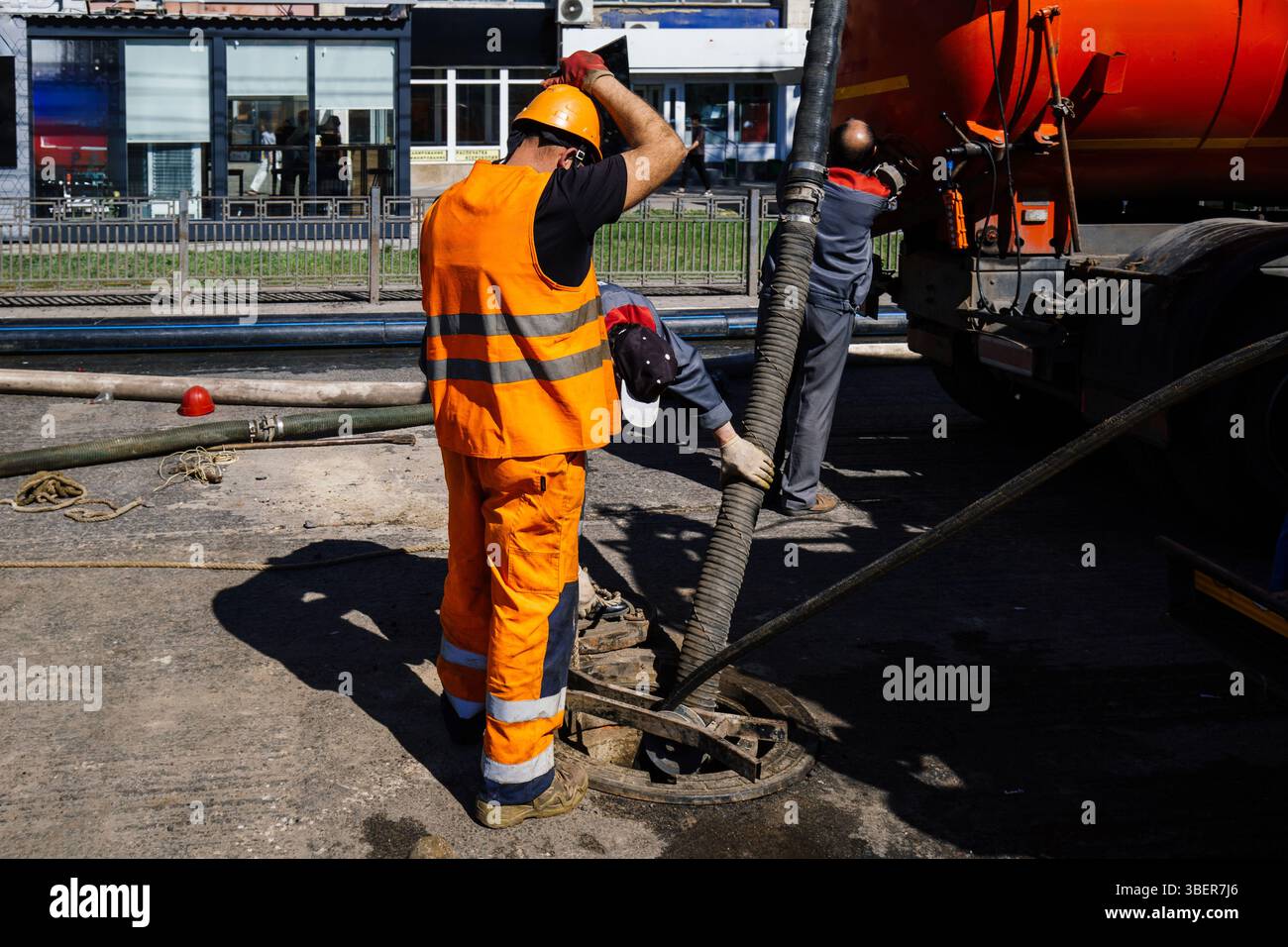 Workers cleaning sewer and pumping sewage into septic tank Stock Photo ...