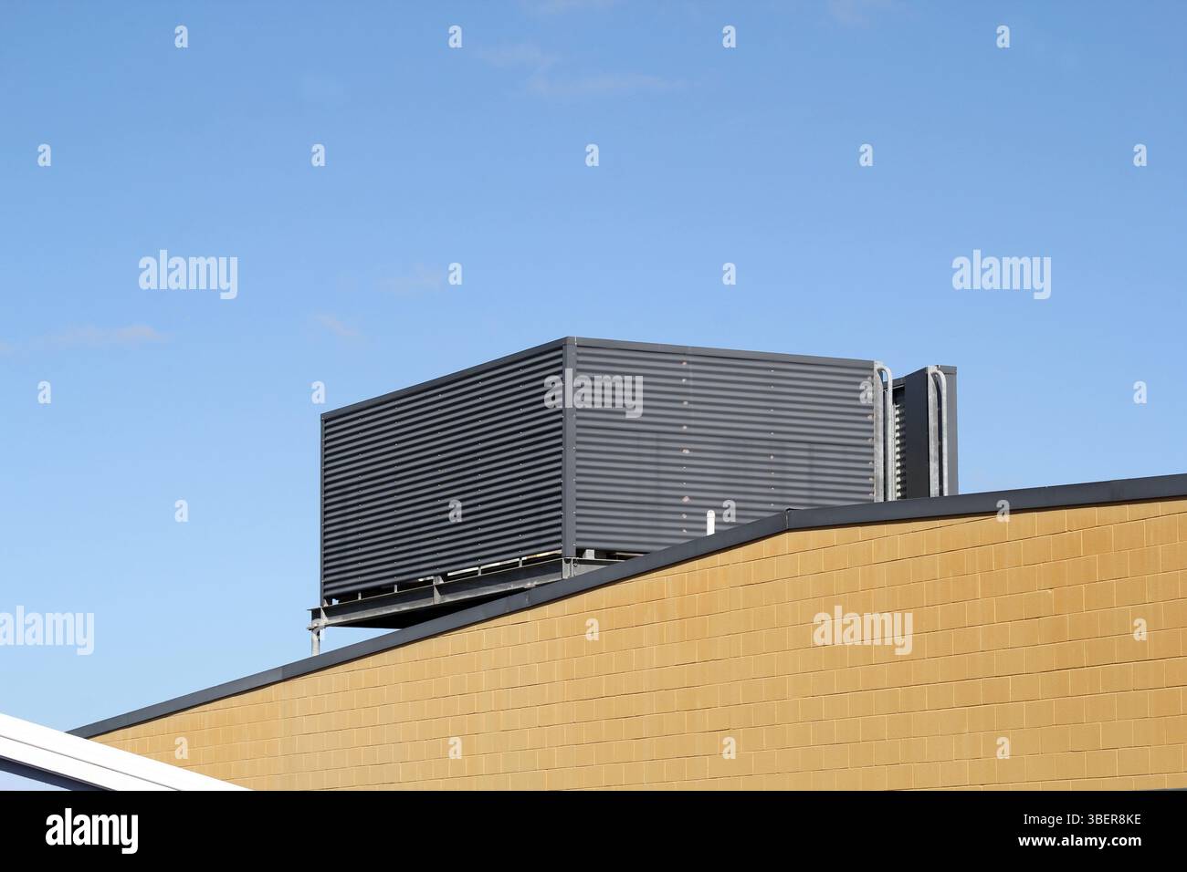 Large air conditioning unit on the roof of a building against a blue ...
