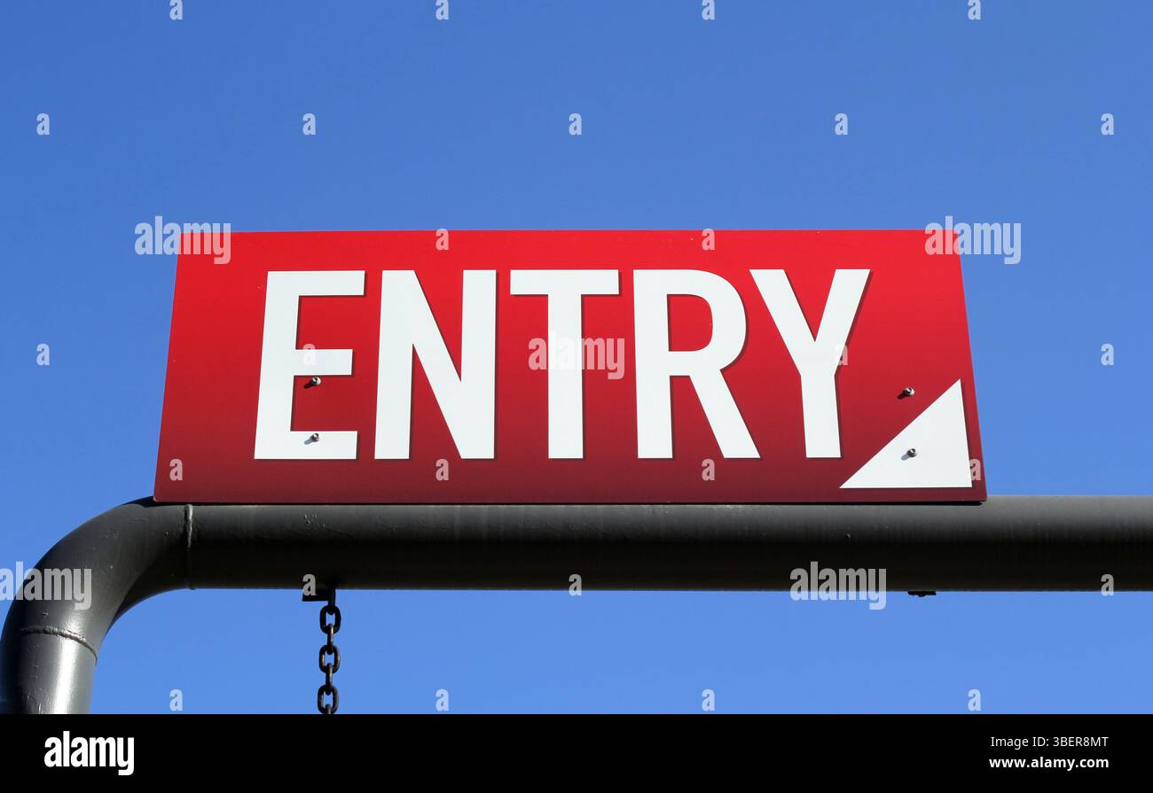 Red Entry sign attached to a black metal beam with a clear blue sky ...