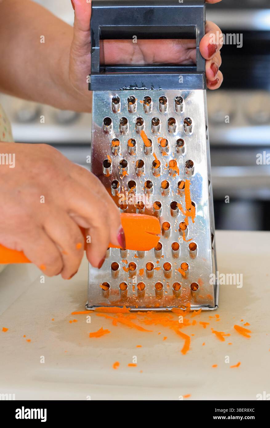 Closeup woman's hands grating carrots Stock Photo - Alamy