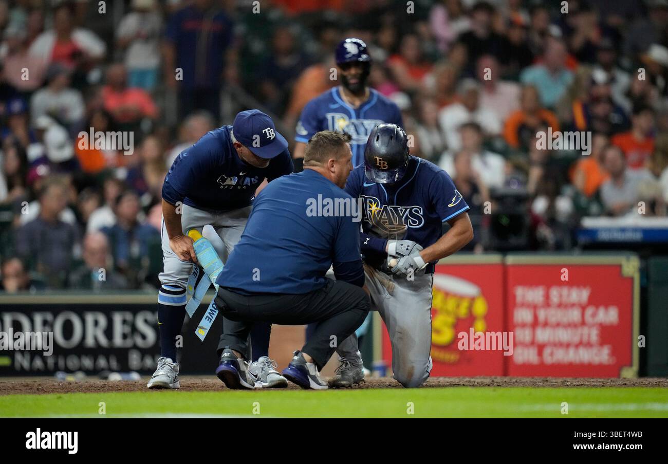 A trainer and Tampa Bay Rays manager Kevin Cash check on Brandon Lowe ...