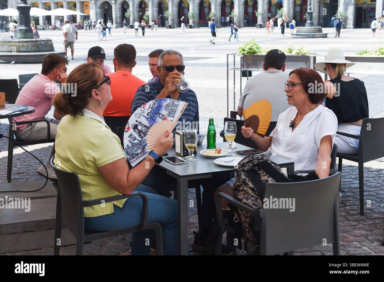 Madrid, Spain. 29th May, 2025. People use fans to cool off at a ...