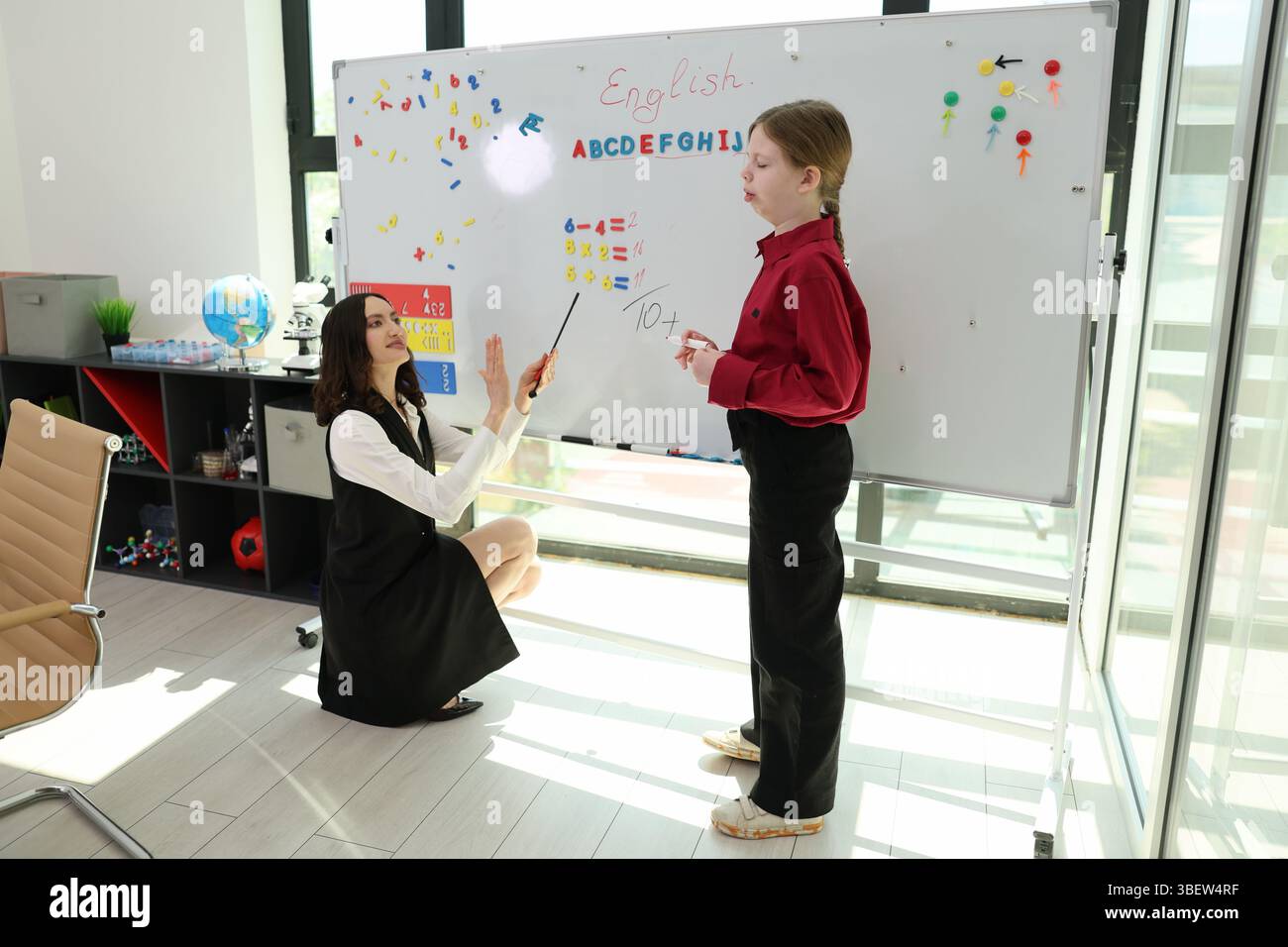 A dedicated teacher engages a curious student in a lively creative ...