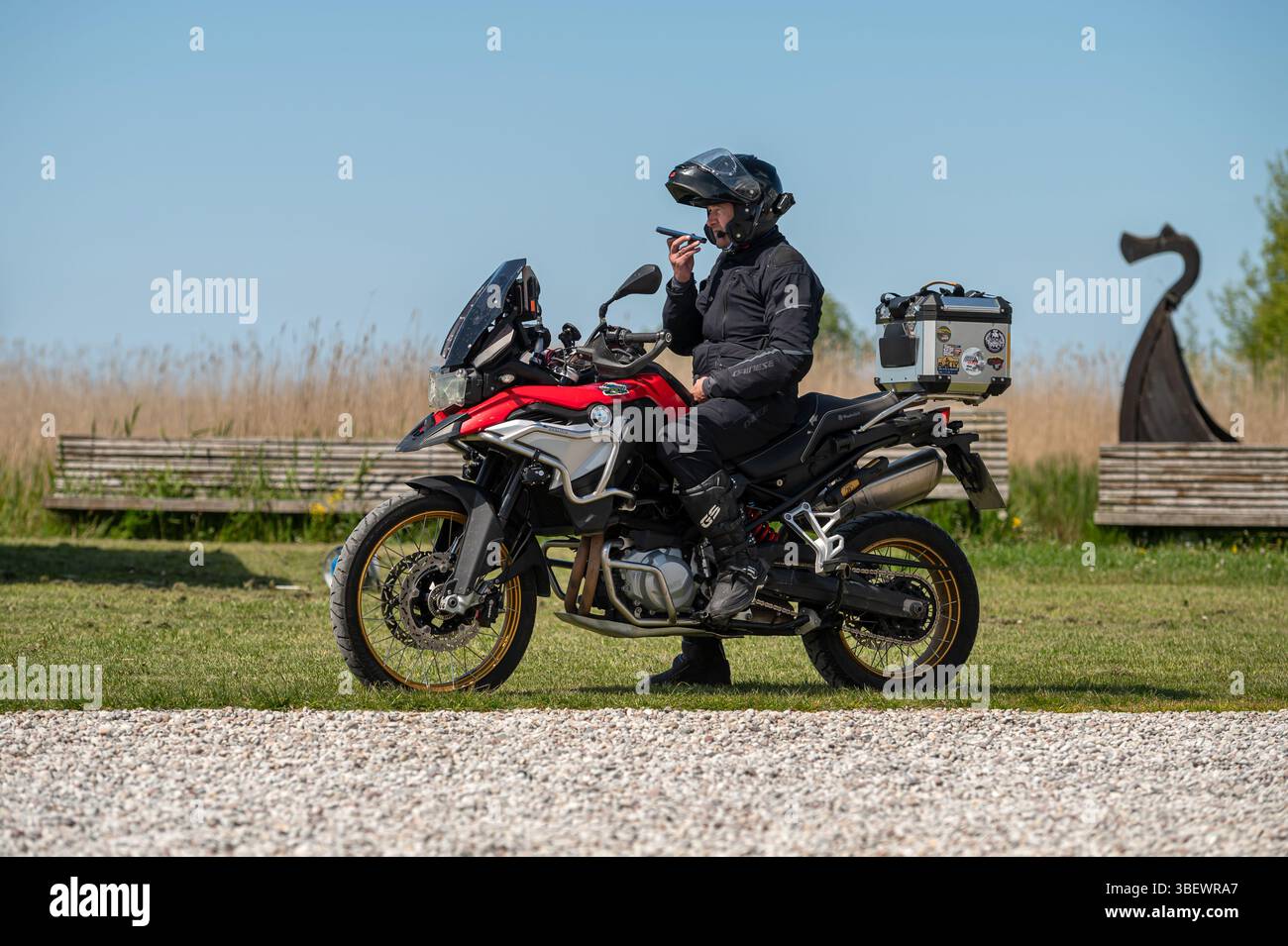 Dreverna, Lithuania - May 24, 2025: A motorcyclist in black gear stops ...