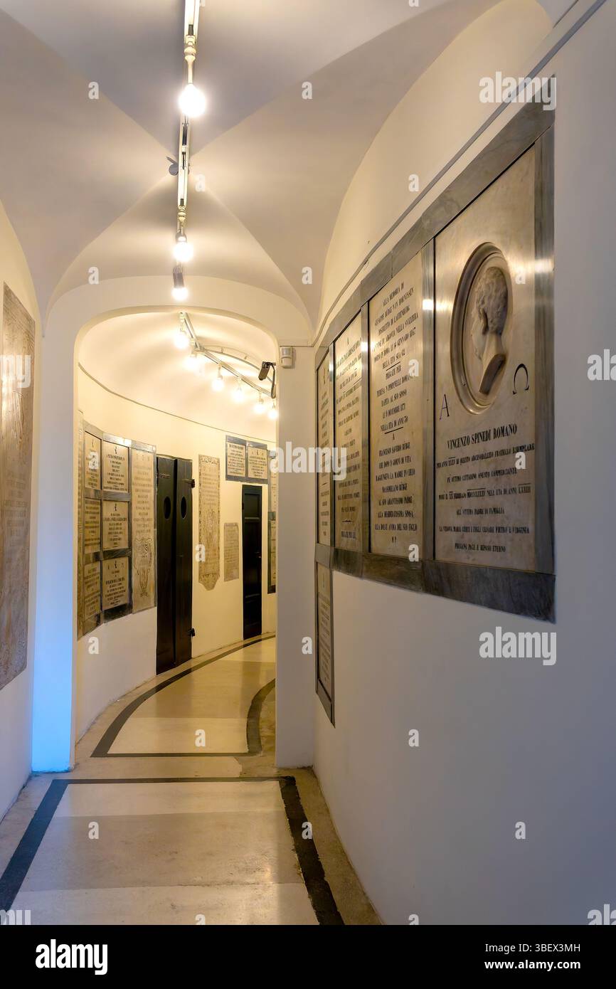 Curved corridor lined with funerary plaques at the crypt entrance of ...