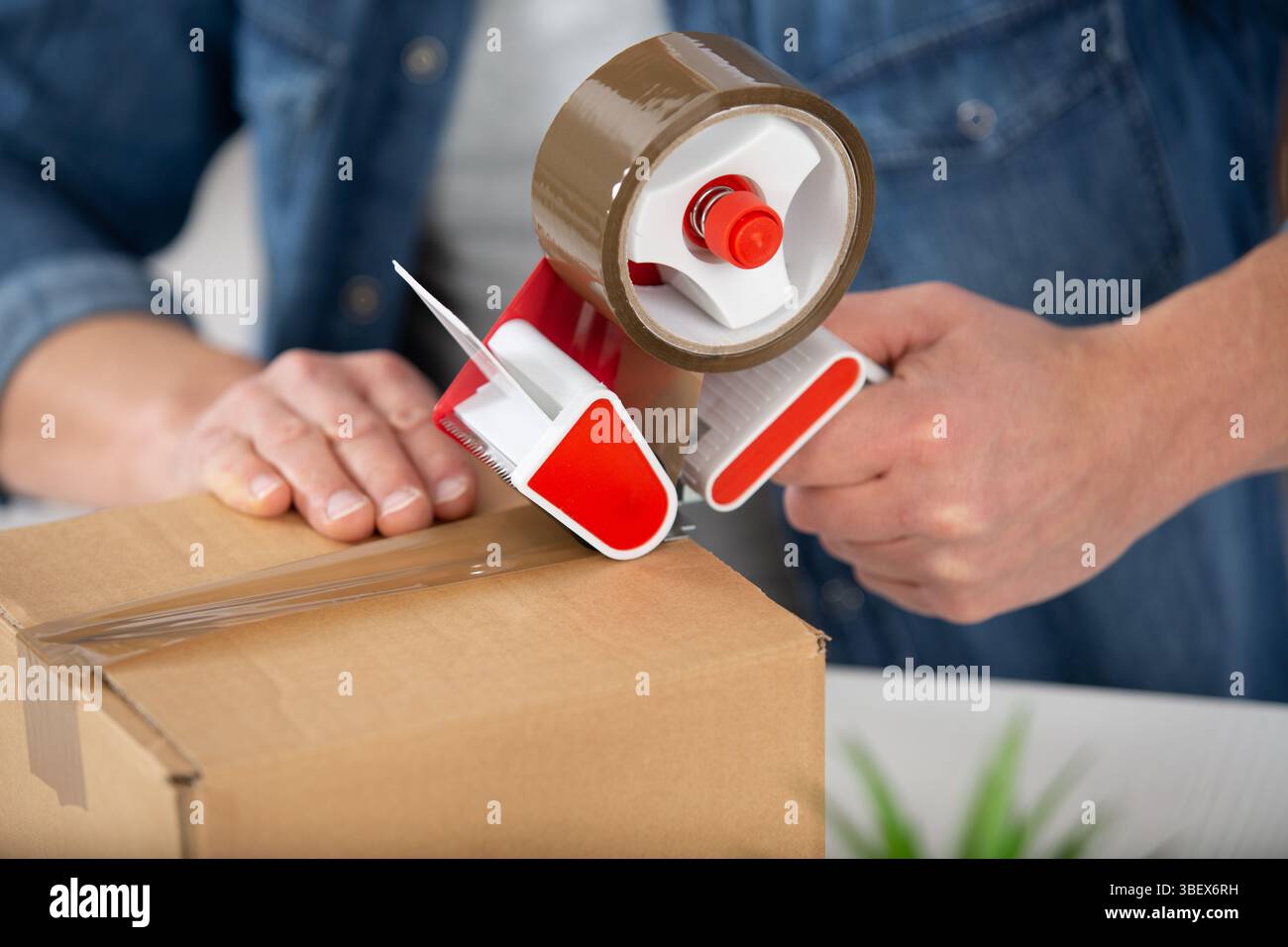 a guy hands sealing cardboard boxes with duct tape Stock Photo - Alamy
