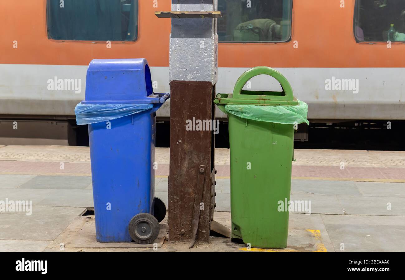 wet and dry dustbin kept at railway station with standing train ...