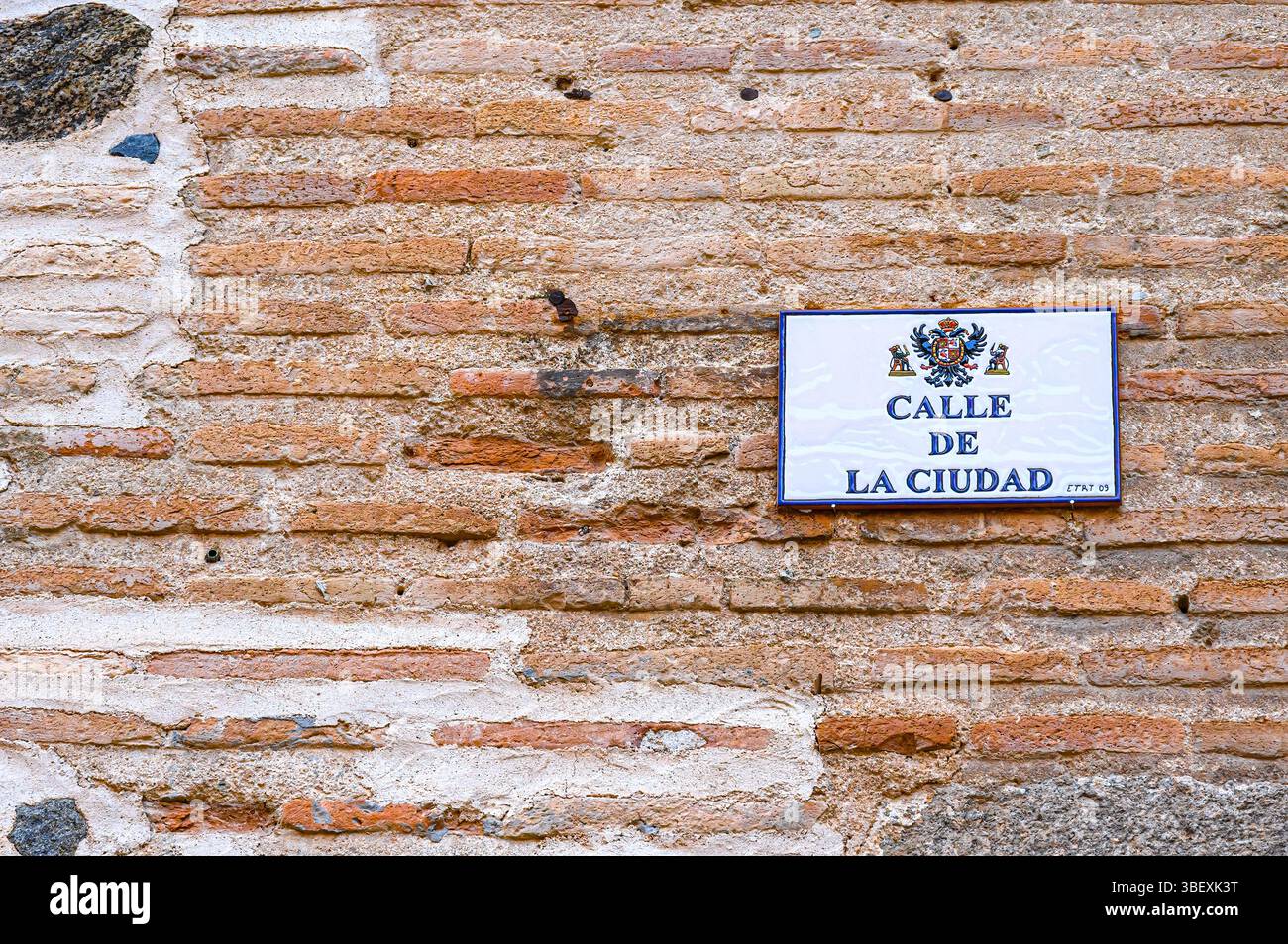 Ceramic street name sign on an ancient brick wall, reading Calle de la ...