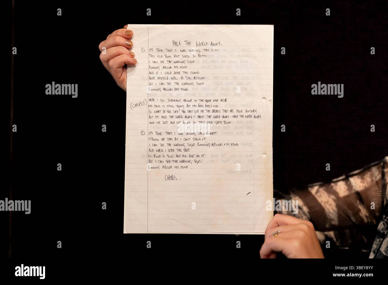 A member of staff looks at handwritten lyrics by Noel Gallagher for ...