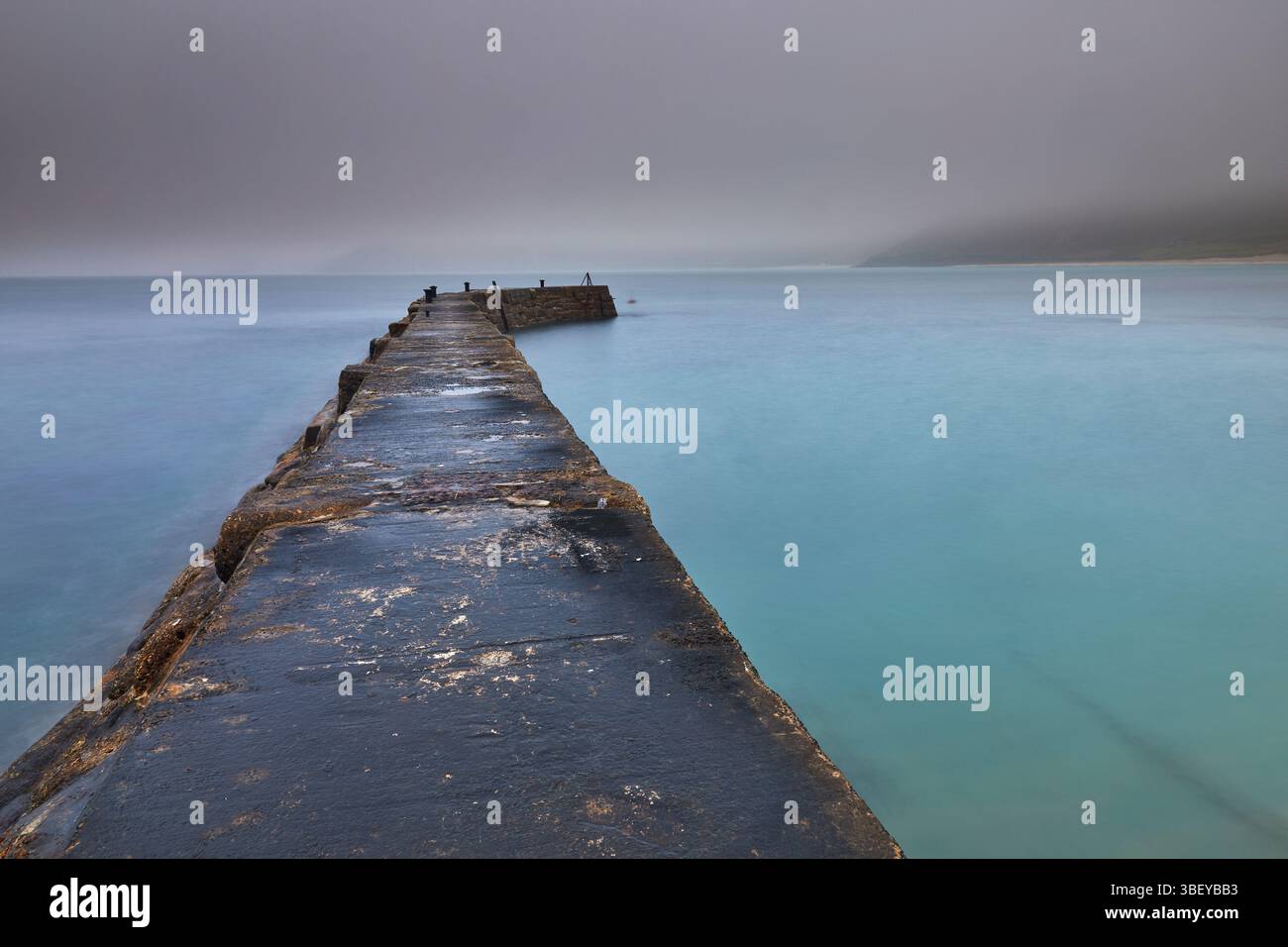 A misty, murky dawn view of the breakwater at Sennen Cove; on the ...