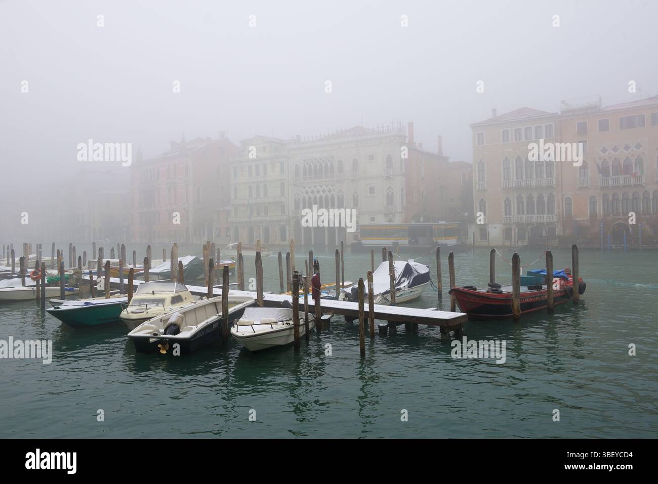 Winter mood in Venice. Snow and frost covered boats, fog over the ...