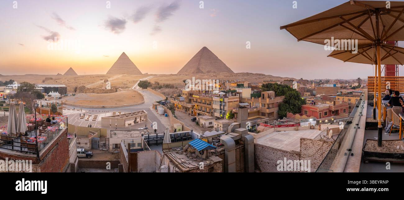 View of Giza Pyramids from rooftop terrace at sunset, Cairo, Egypt ...