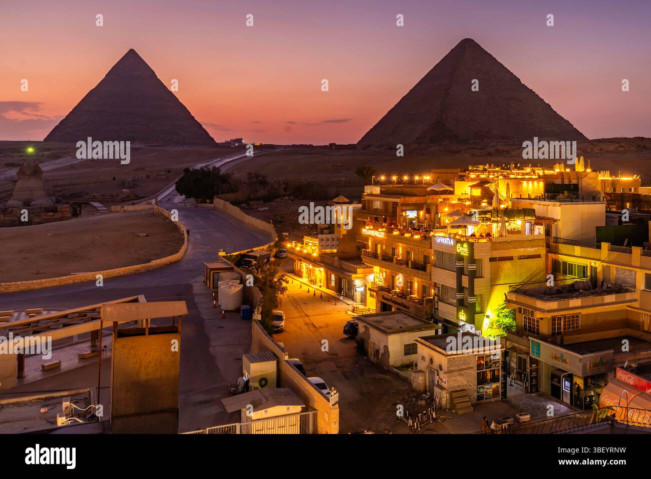 View of Giza Pyramids from rooftop terrace at dusk, Cairo, Egypt ...