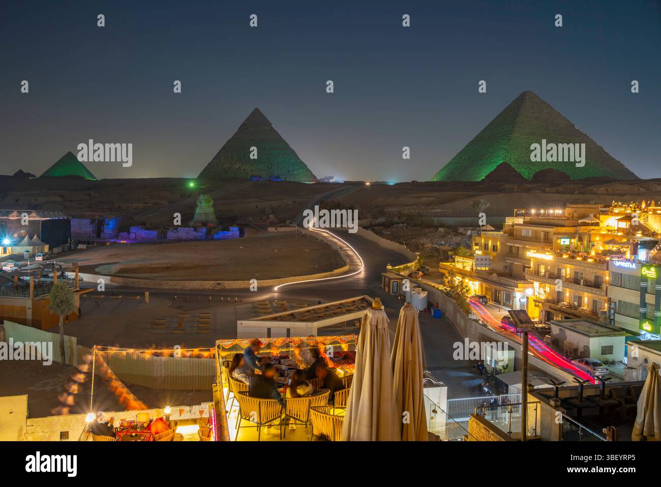 View of Giza Pyramids from rooftop terrace during light show, Cairo ...