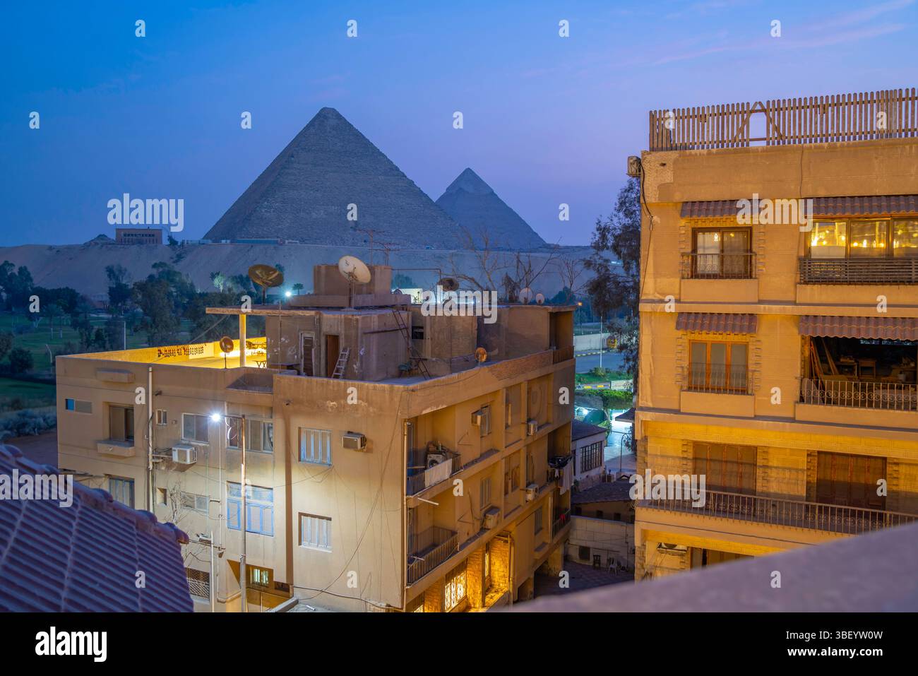 View of the Giza Pyramids from rooftop terrace at dusk, Giza, Cairo ...