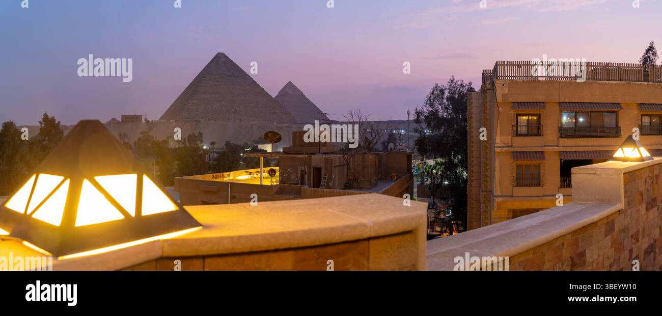 View of the Giza Pyramids from rooftop terrace at dusk, Giza, Cairo ...