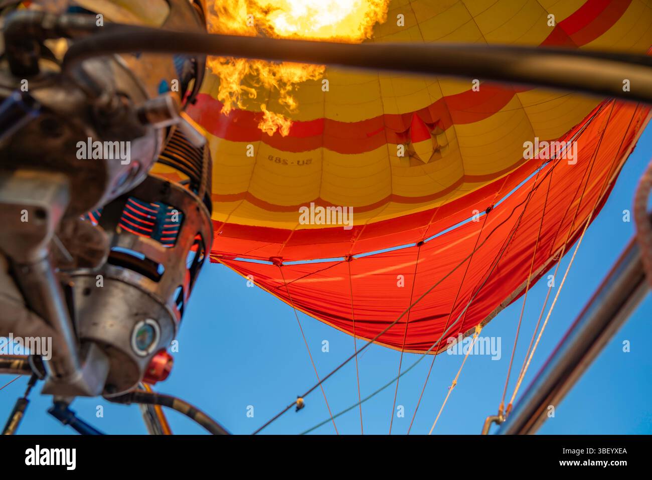 View of flame into hot air balloon over Luxor at sunrise, Luxor, Egypt ...