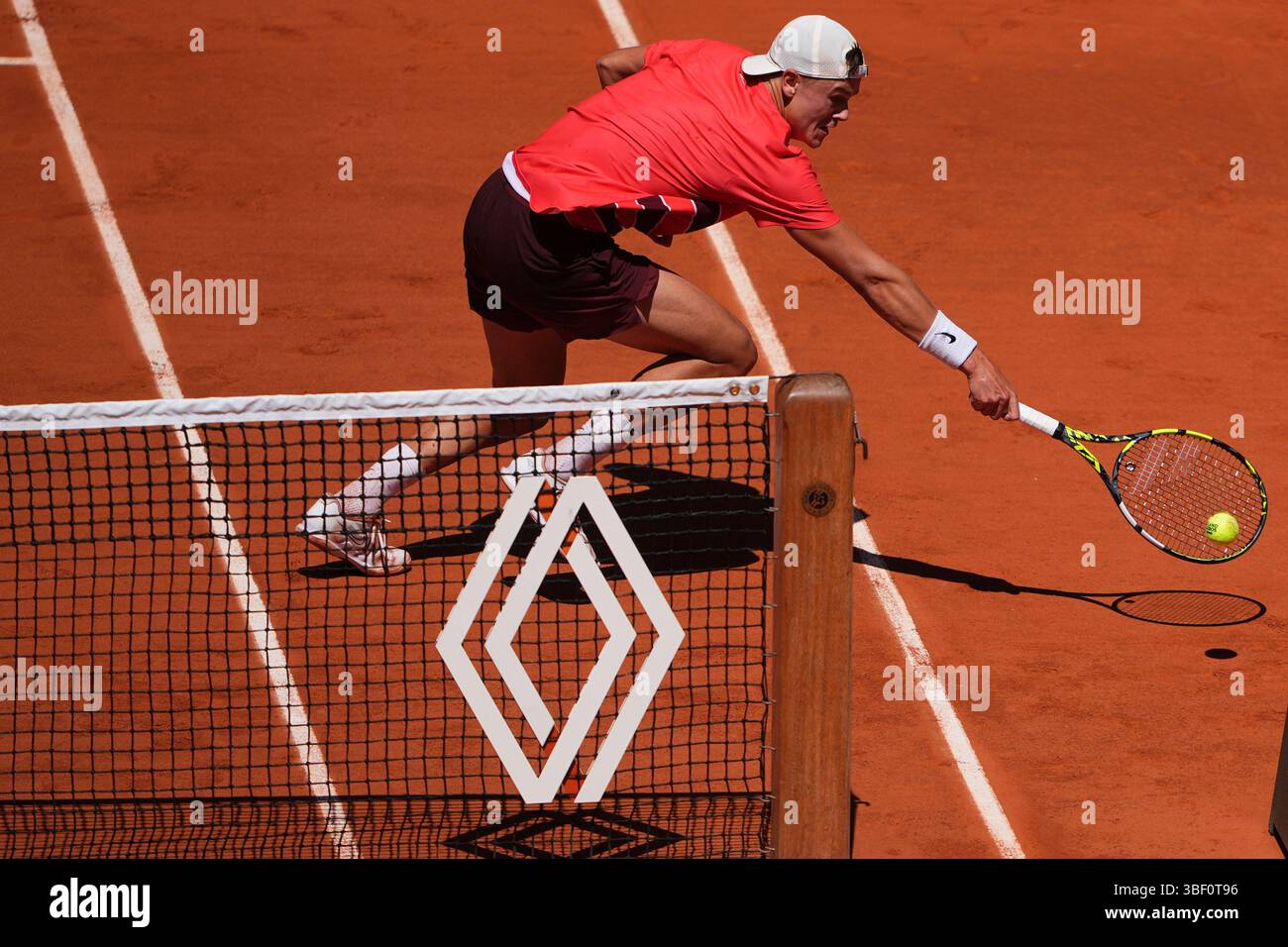 Denmark's Holger Rune scores a point from beside the net as he plays ...
