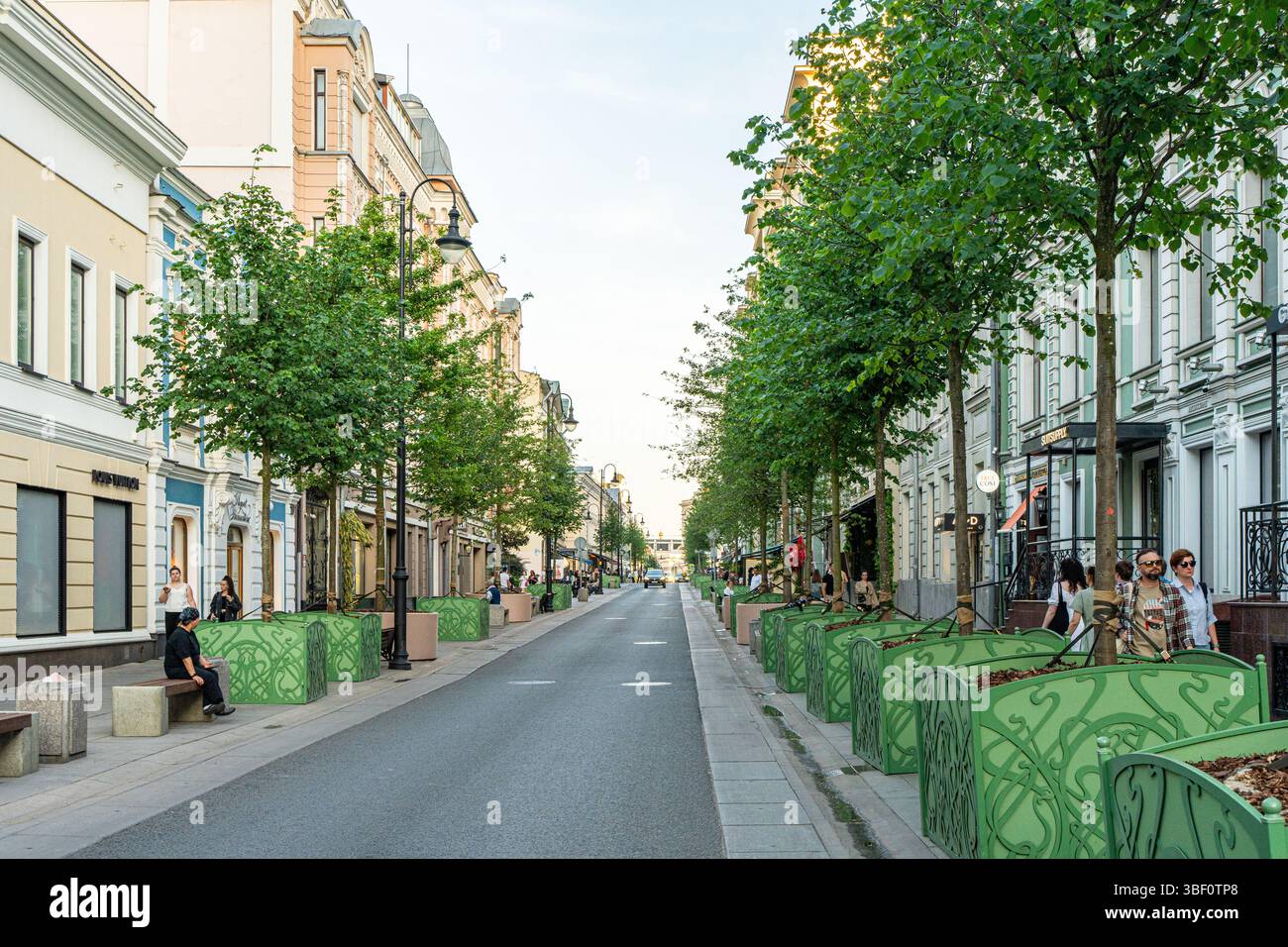 Moscow, Russia, May 27, 2025: A road in the city center leading to the Bolshoi Theater. Trees in ...