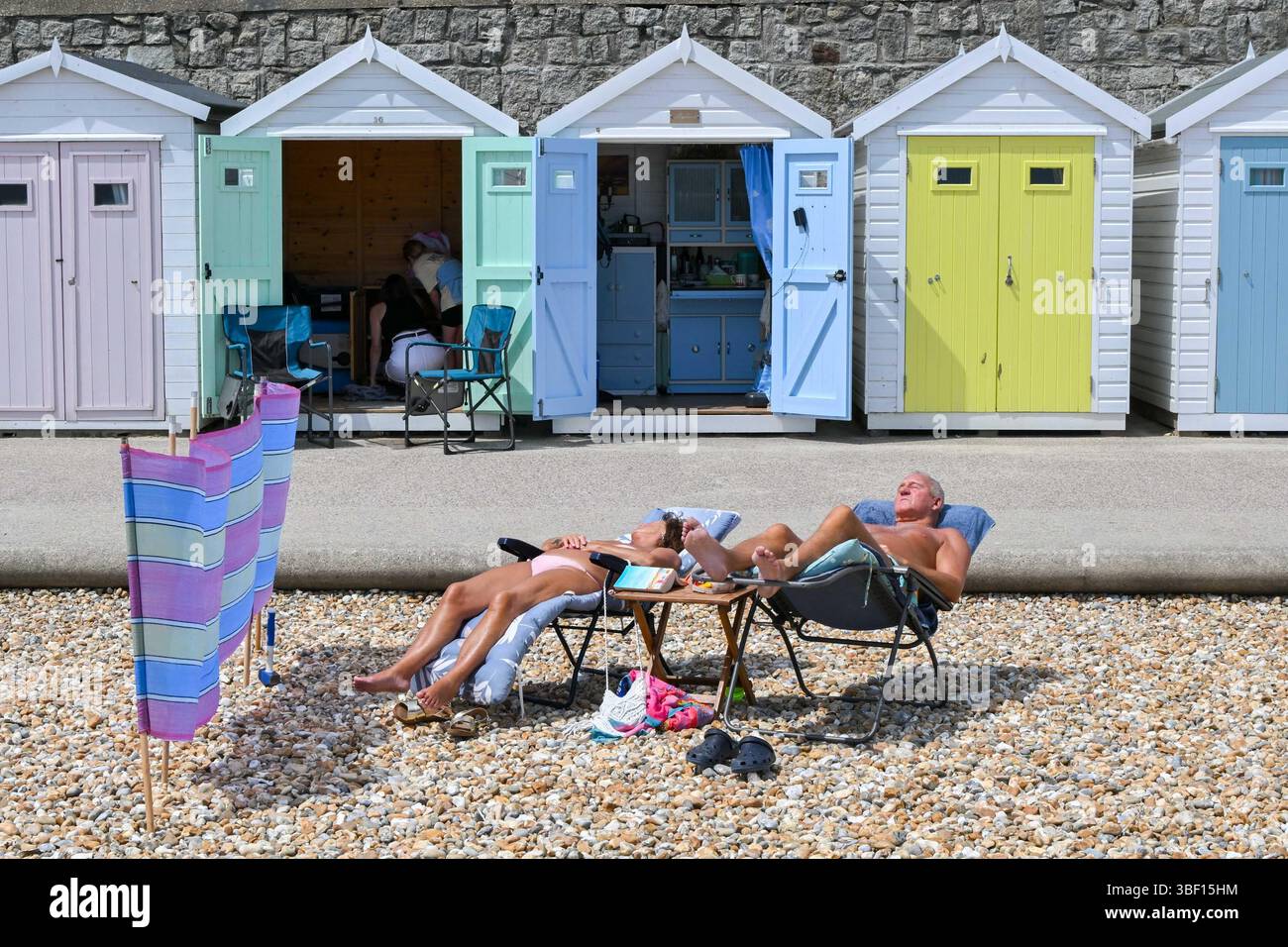 Lyme Regis, Dorset, UK. 30th May 2025. UK Weather. Sunbathers on the beach enjoying the ...
