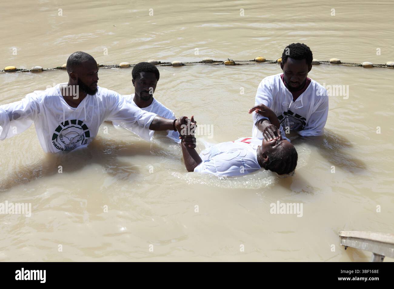 Zambian Christian man being baptised by three men holding his hand ...