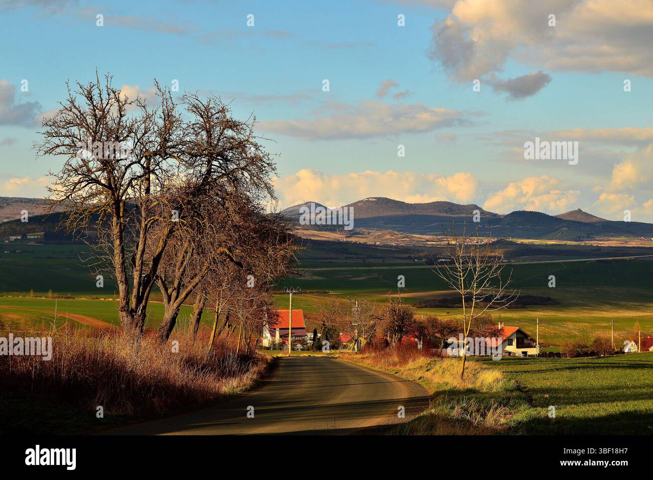Country Road Through Hills Under Shifting Stormy Clouds and Variable ...