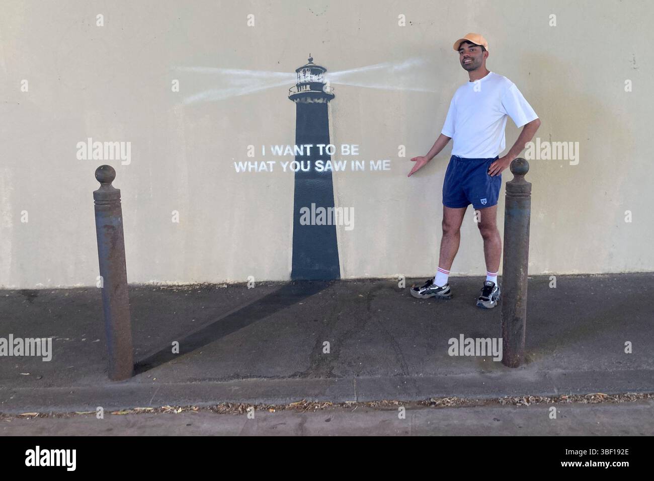 A man poses by an artwork by street artist Banksy, Friday, May 30, 2025 ...