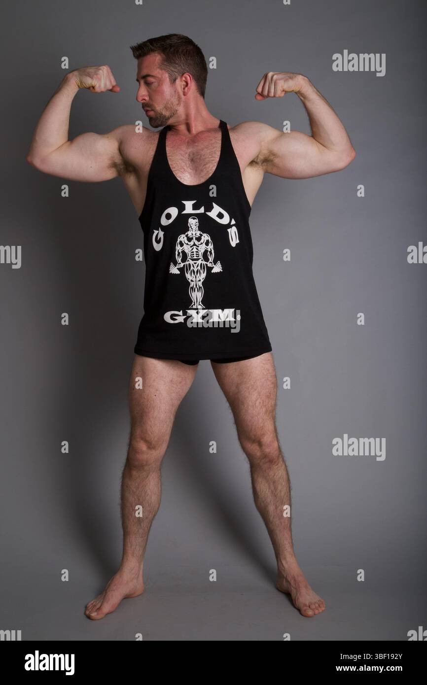 Man wearing oversized stringer vest and flexing his biceps Stock Photo ...