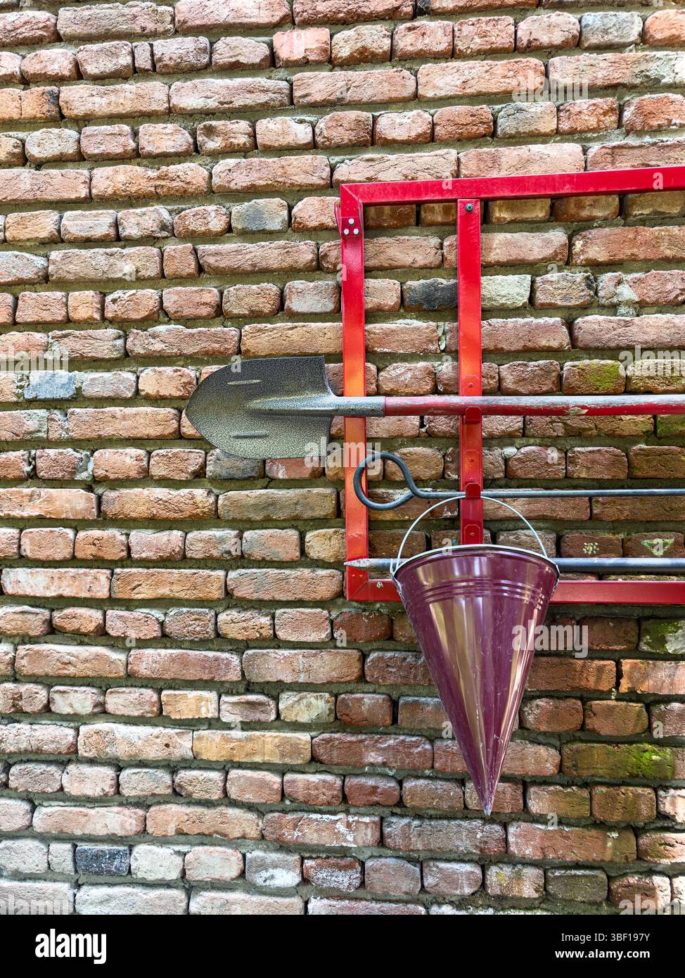 Firefighting tool set on brick wall,red frame with metal shovel, fire ...