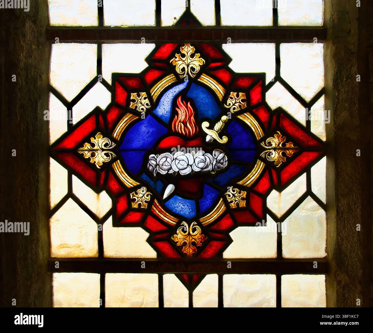 Stained glass window with an image the Immaculate Heart of Mary pierced ...