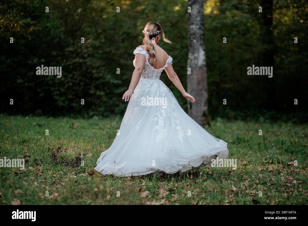 The image captures a bride in an elegant white wedding dress standing ...