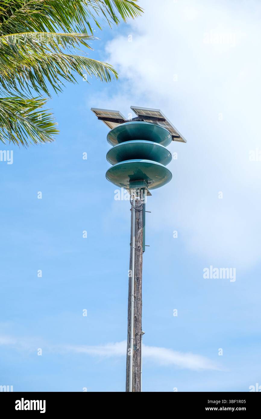 A solar-powered siren stands tall against a blue sky, ready to alert ...