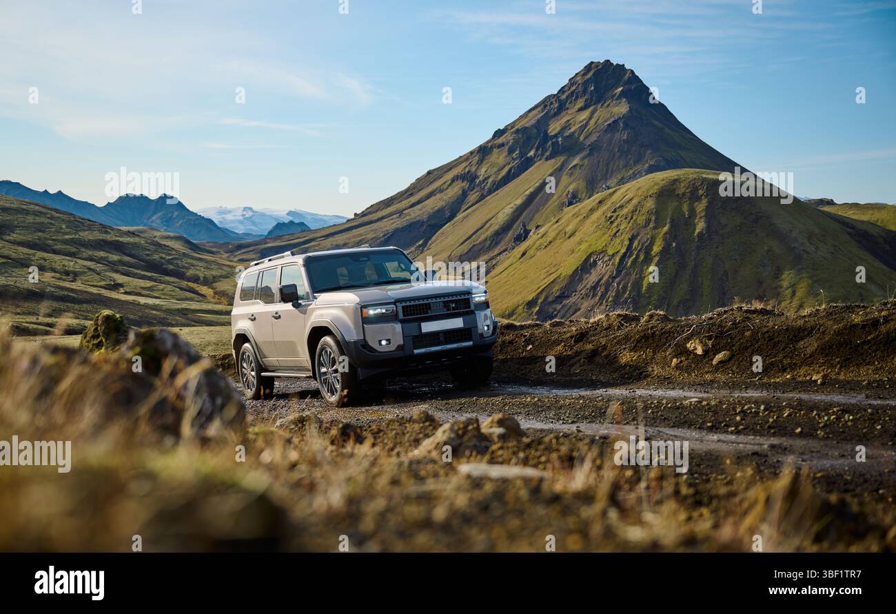 Modern suv car driving on dirt road in mountain valley landscape Stock ...
