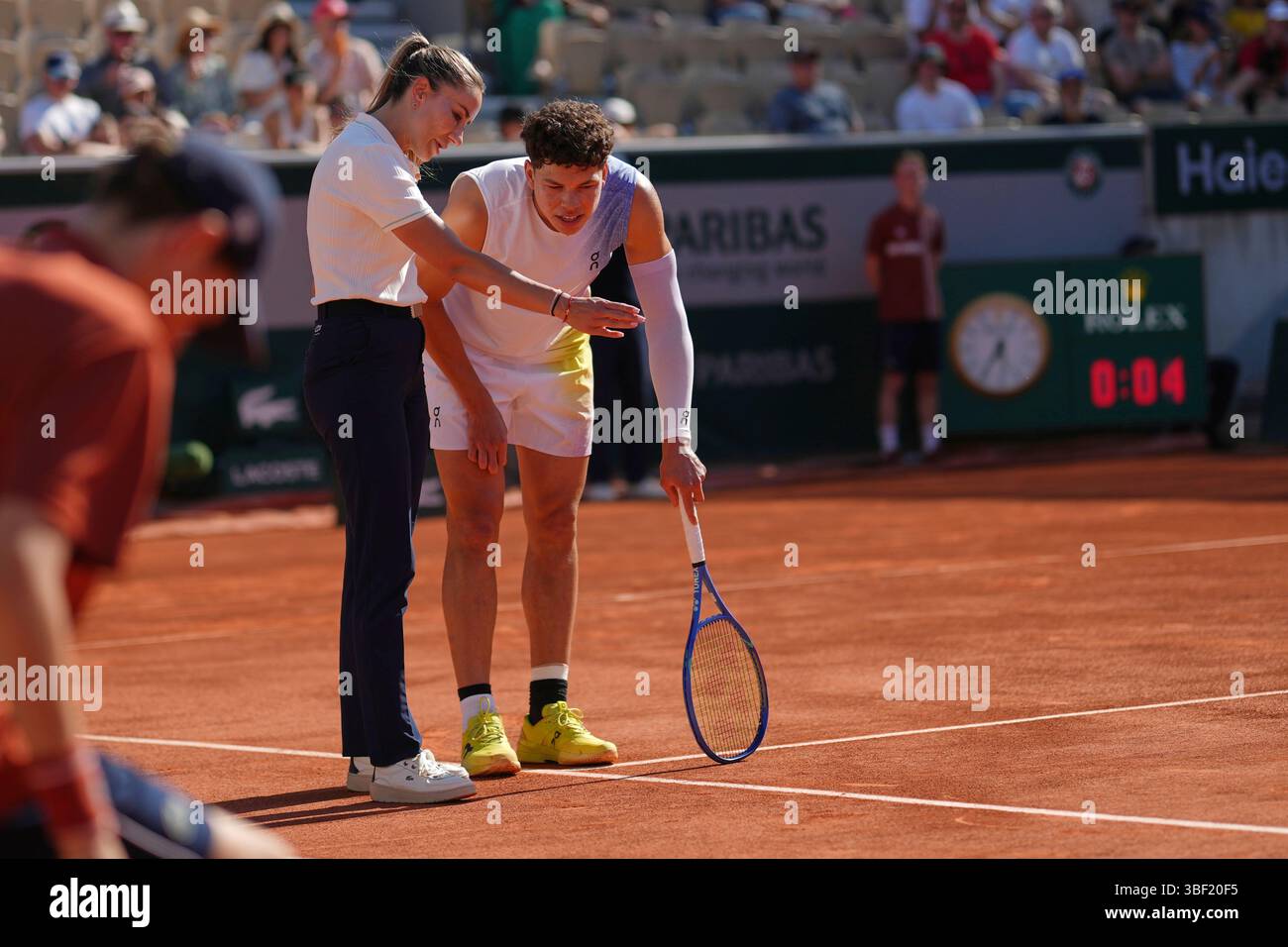 Ben Shelton of the U.S. is flanked by the chair umpire as he checks a ...