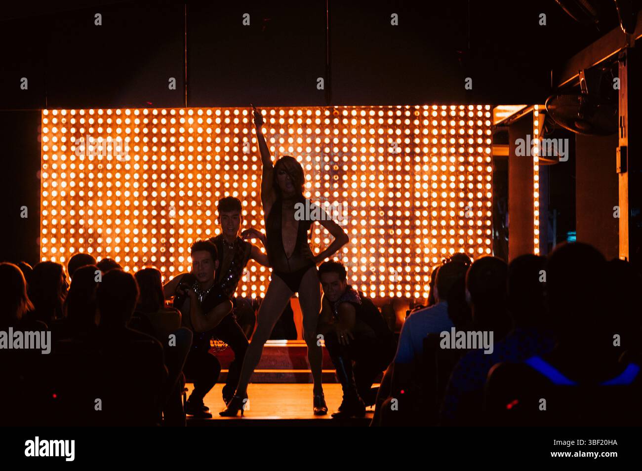 Fierce stage pose in a fiery cabaret spotlight Stock Photo - Alamy