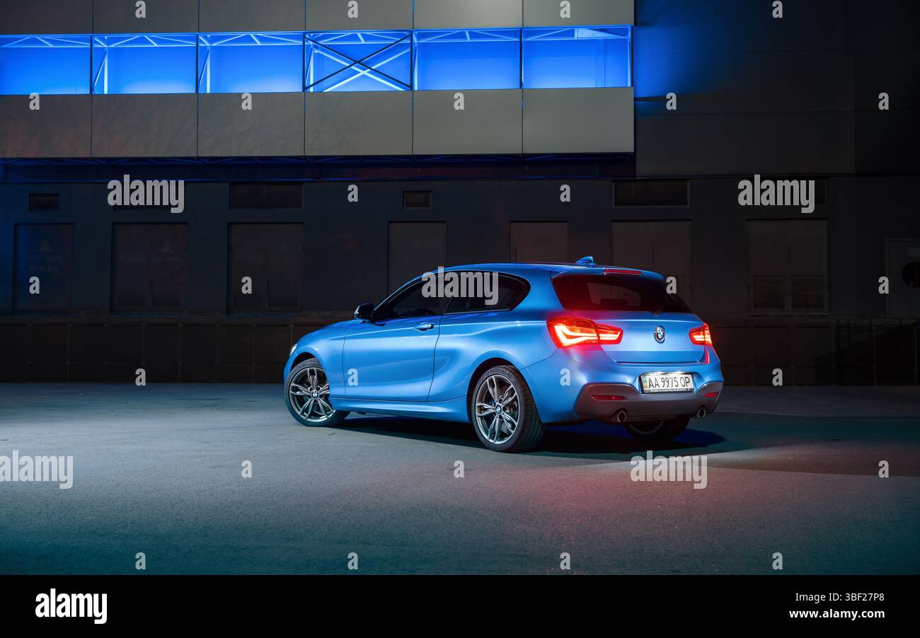Blue BMW M140i in night city. Three quarter rear view of sporty BMW 1 ...