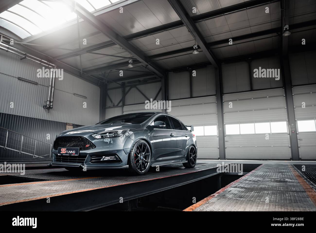 grey Ford Focus ST in empty garage. Wide-angle three quarter front view of sedan parked in empty ...