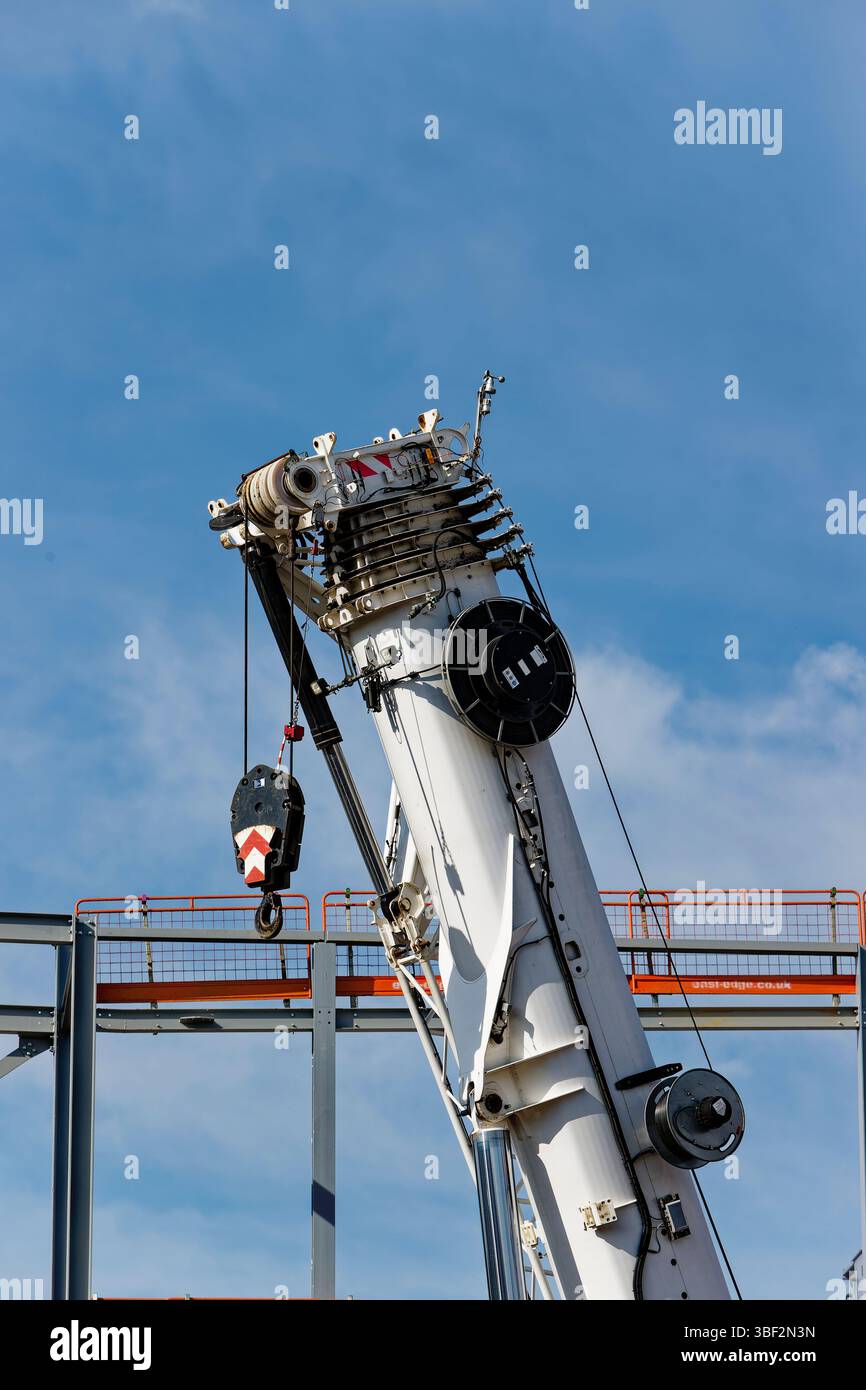 White hydraulic mobile crane boom retracted and elevated with steel ...