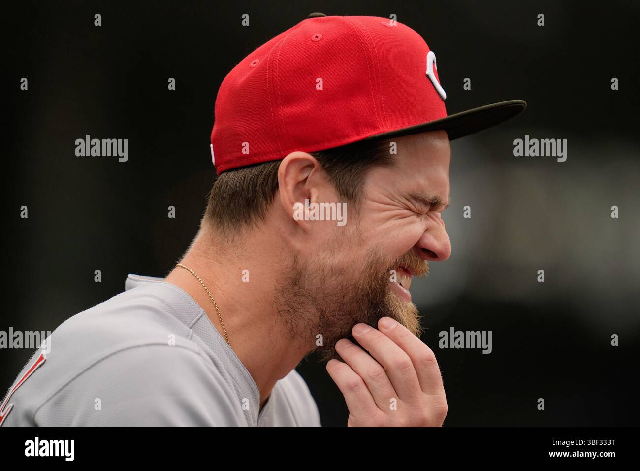 Cincinnati Reds first base coach Collin Cowgill (54) sits in the dugout ...