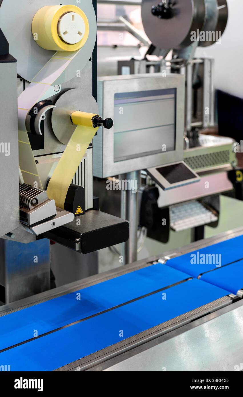 Automatic labeling machine on packaging line in modern factory Stock ...