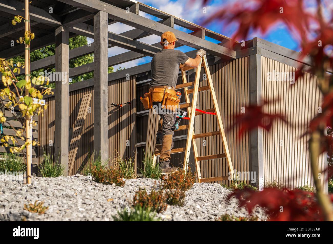 A construction worker is using a ladder to reach the top of a building ...