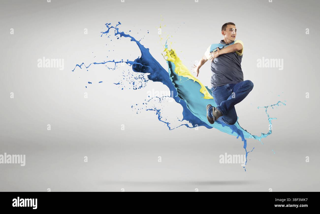 Modern style dancer in jump and color paint splashes at background ...