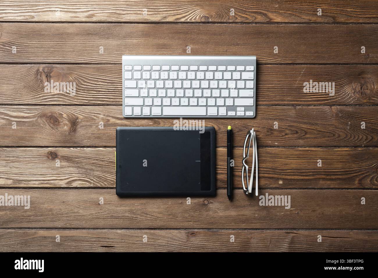 Top view office workspace composition. Flat lay vintage wooden desk with pc keyboard and graphic ...