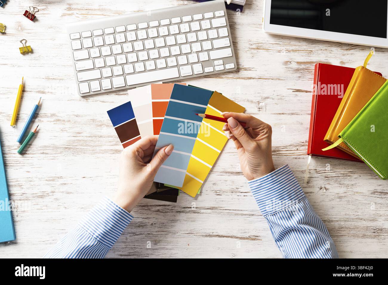 Interior designer choosing colors from swatches at wooden desk. Office ...