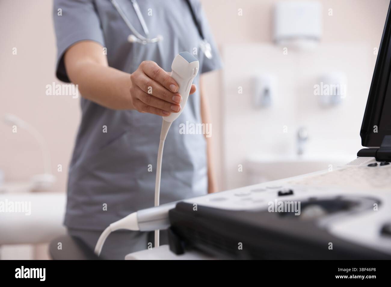 Sonographer with transducer and ultrasound machine in clinic, closeup ...