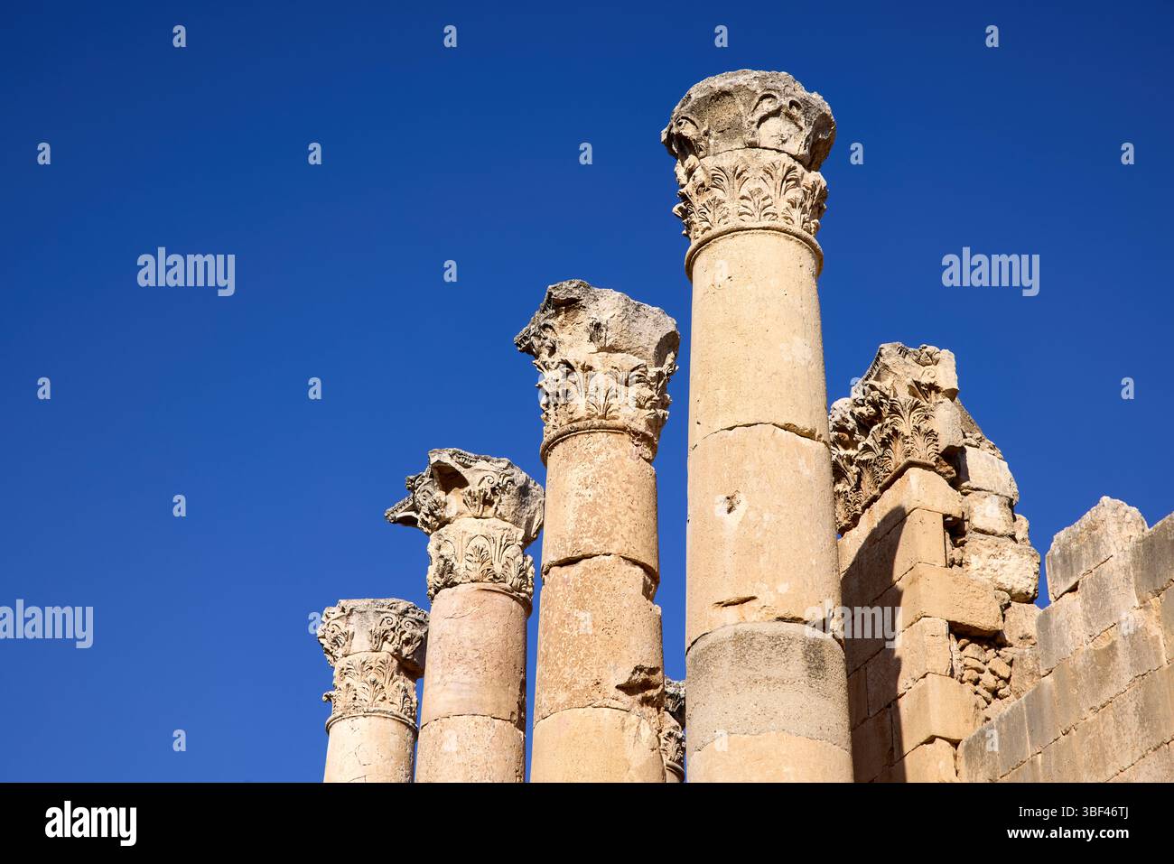 Majestic columns of ancient Jerash rise against a vibrant blue sky ...