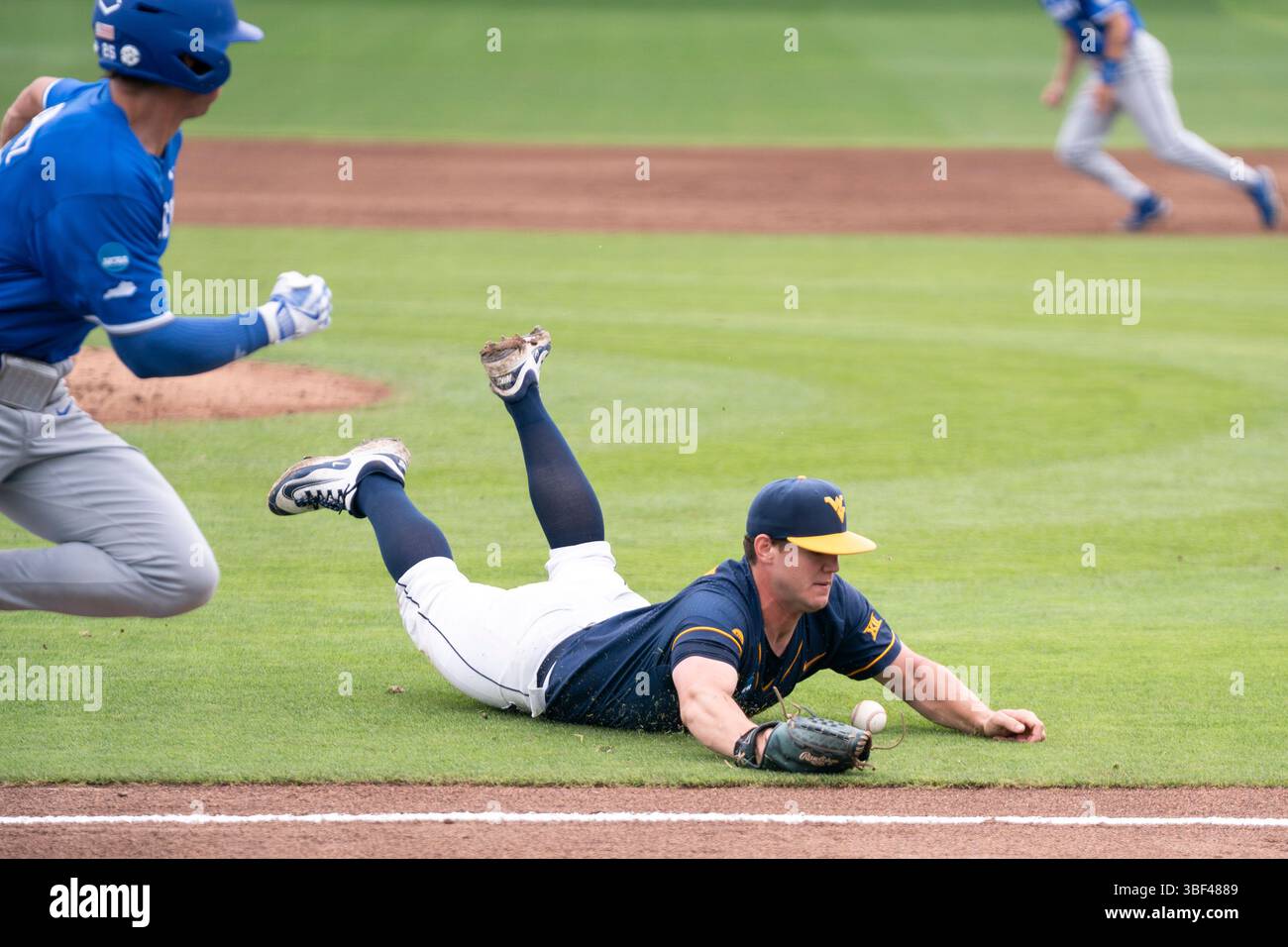 West Virginia pitcher Griffin Kirn dives for the ball during an NCAA ...